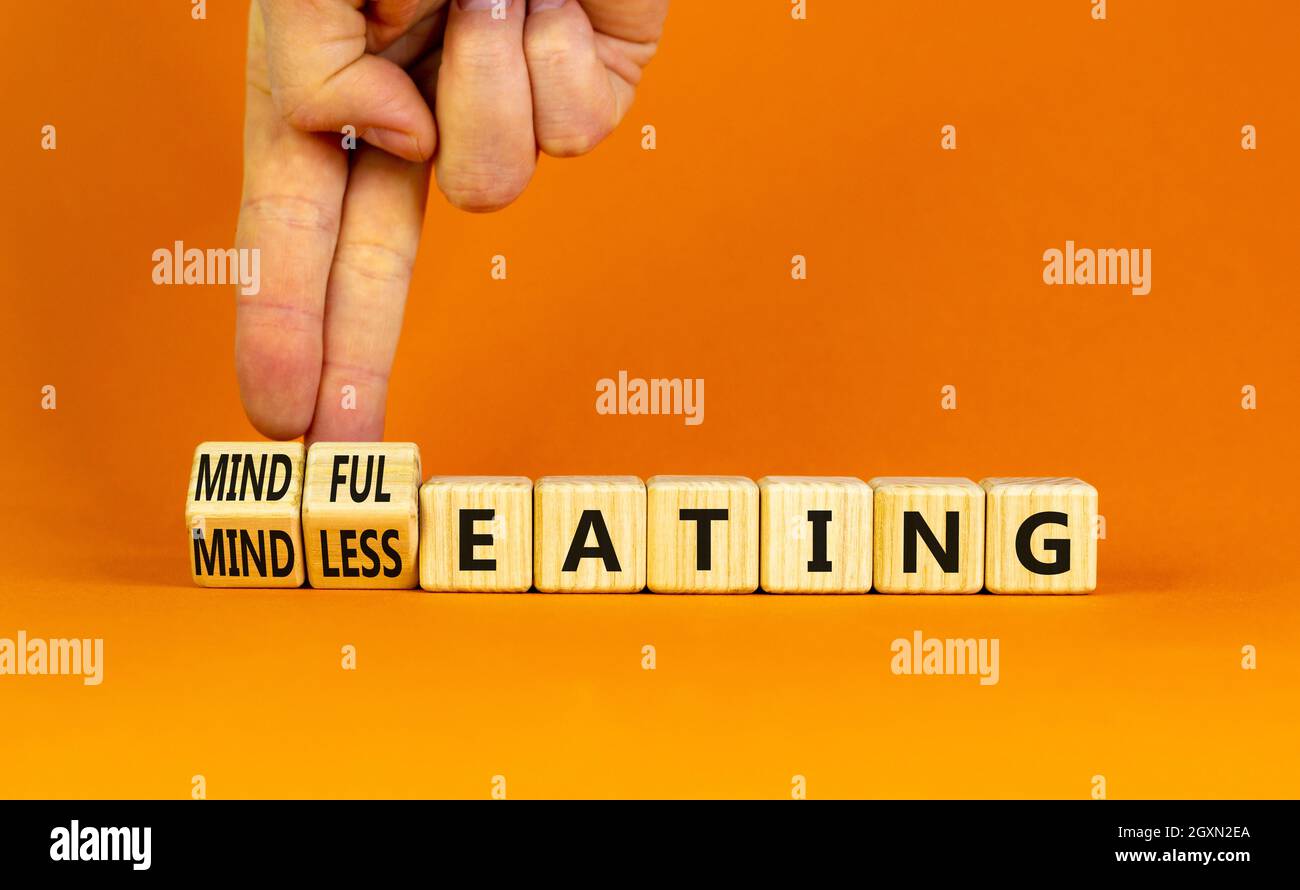 Mindful or mindless eating symbol. Doctor turns cubes and changes words ...