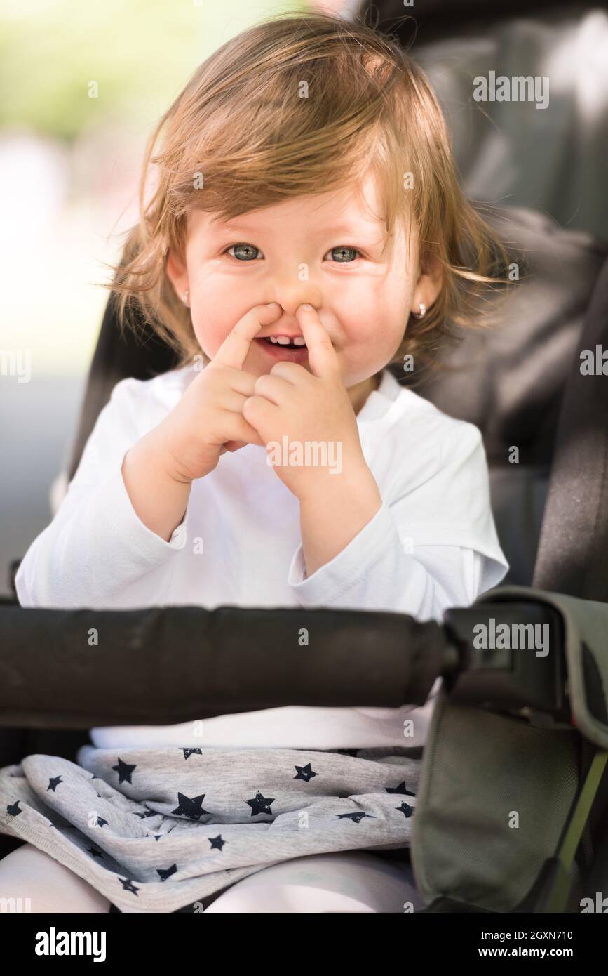 little and very beautiful baby girl sitting in the pram and waiting for ...