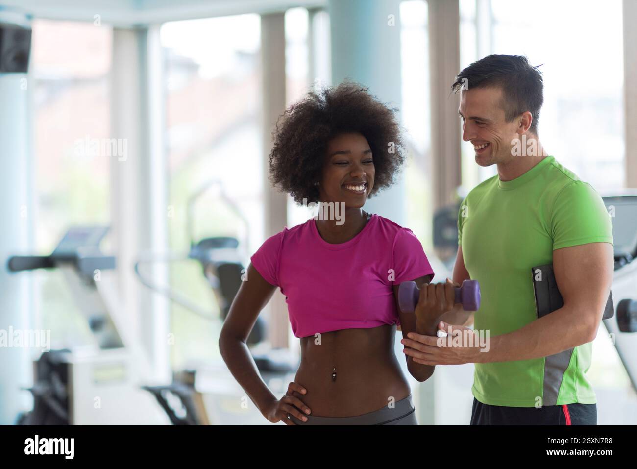 healthy young couple in crossfit gym weights workout with personal ...