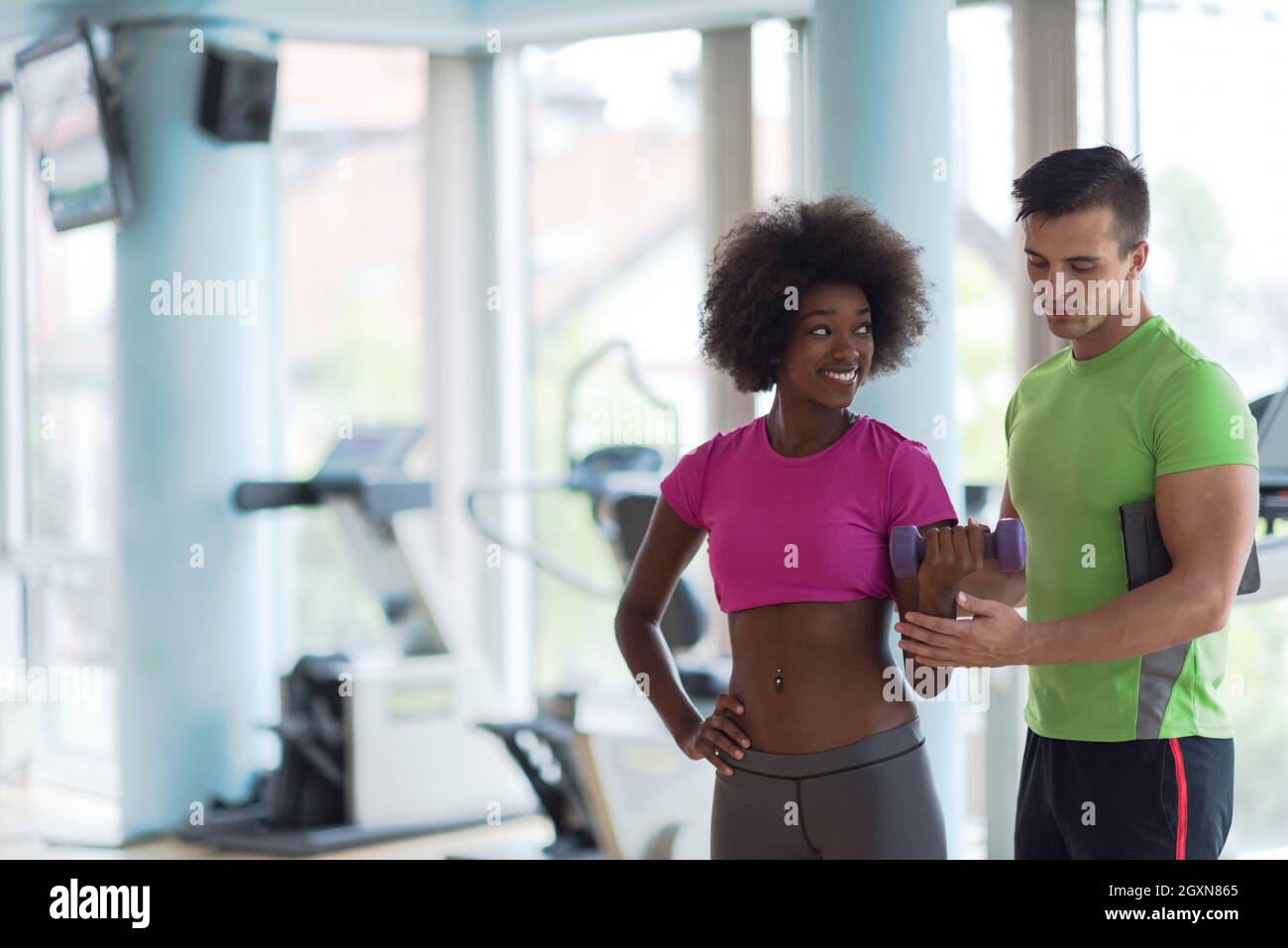 healthy young couple in crossfit gym weights workout with personal ...