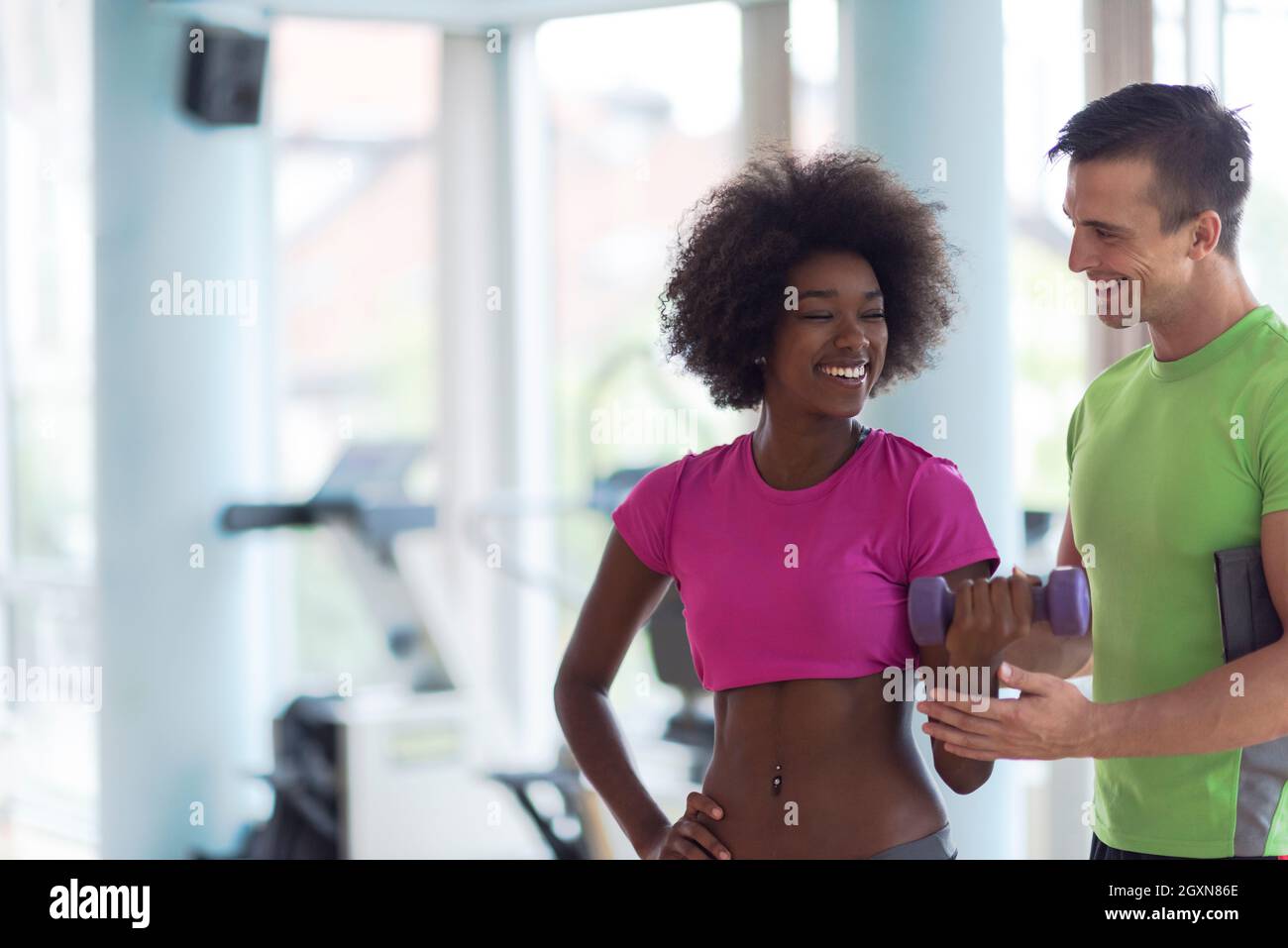 healthy young couple in crossfit gym weights workout with personal ...