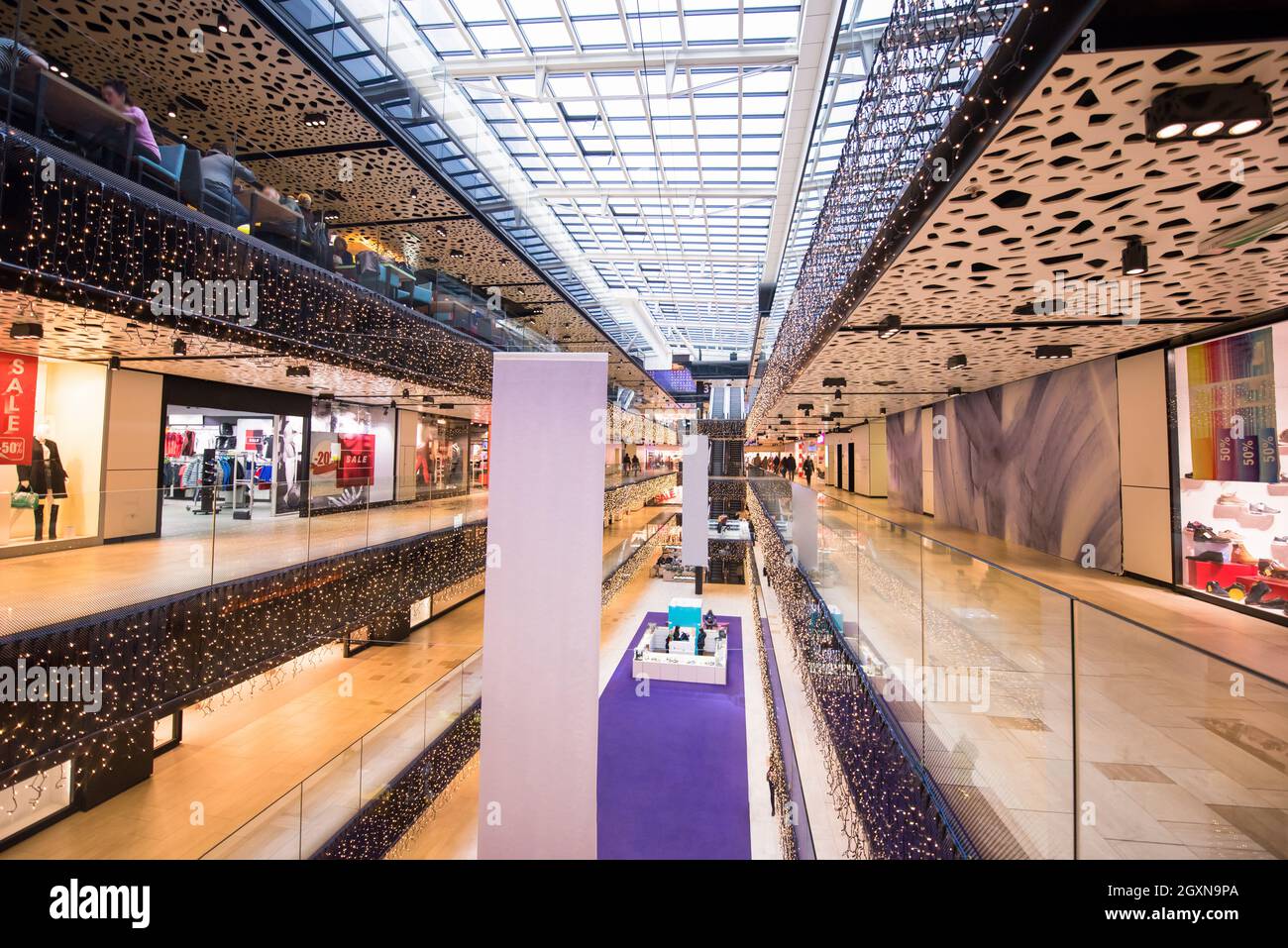 Shoppers walking through luxury shopping mall interior Interior of big ...