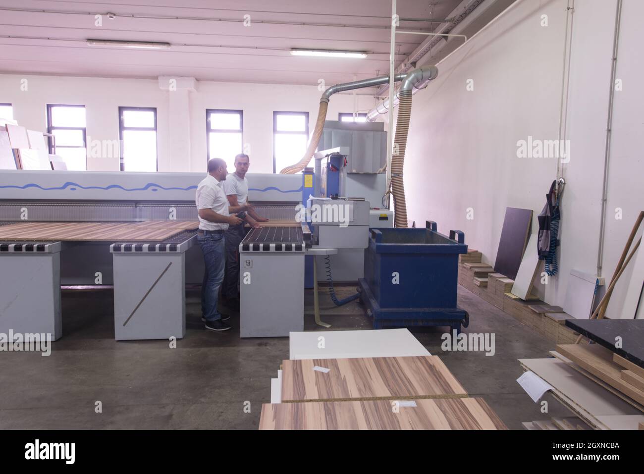 two worker working in a factory for the production of wooden furniture ...