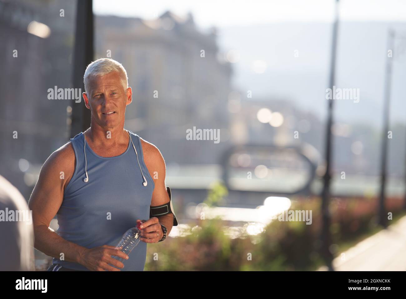 portrait of handsome senior jogging man while relaxing and take break ...