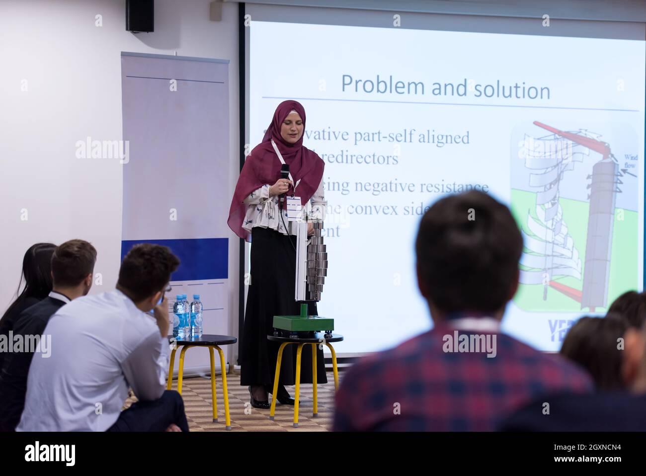 young muslim businesswoman with red scarf at business conference room giving public ...