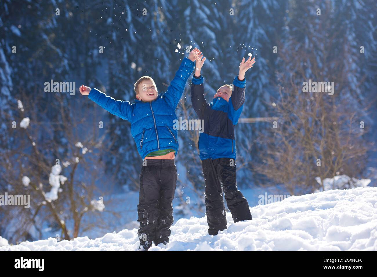 happy kids playing in fresh snow at beautiful sunny winter day Stock ...