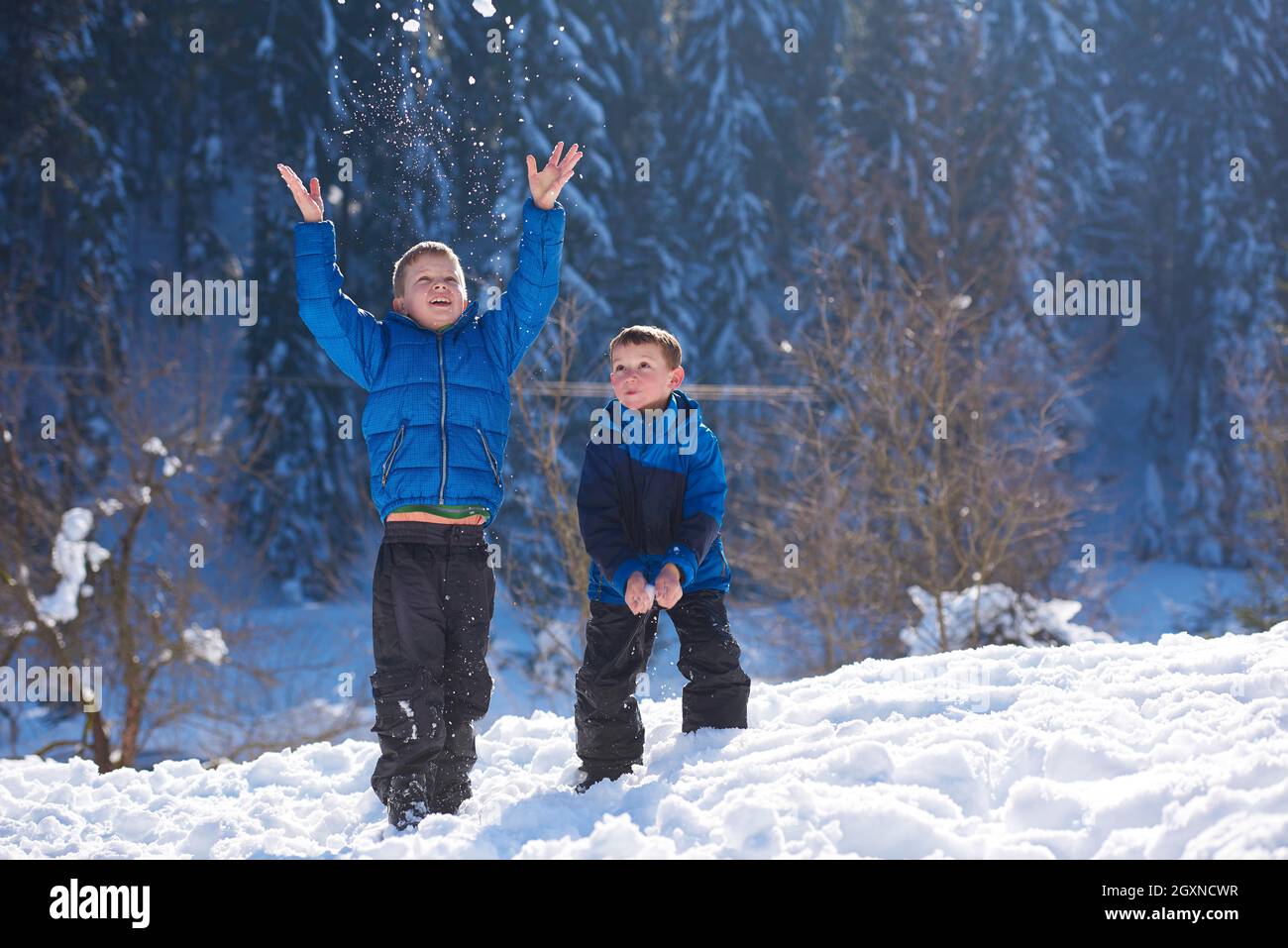 happy kids playing in fresh snow at beautiful sunny winter day Stock ...