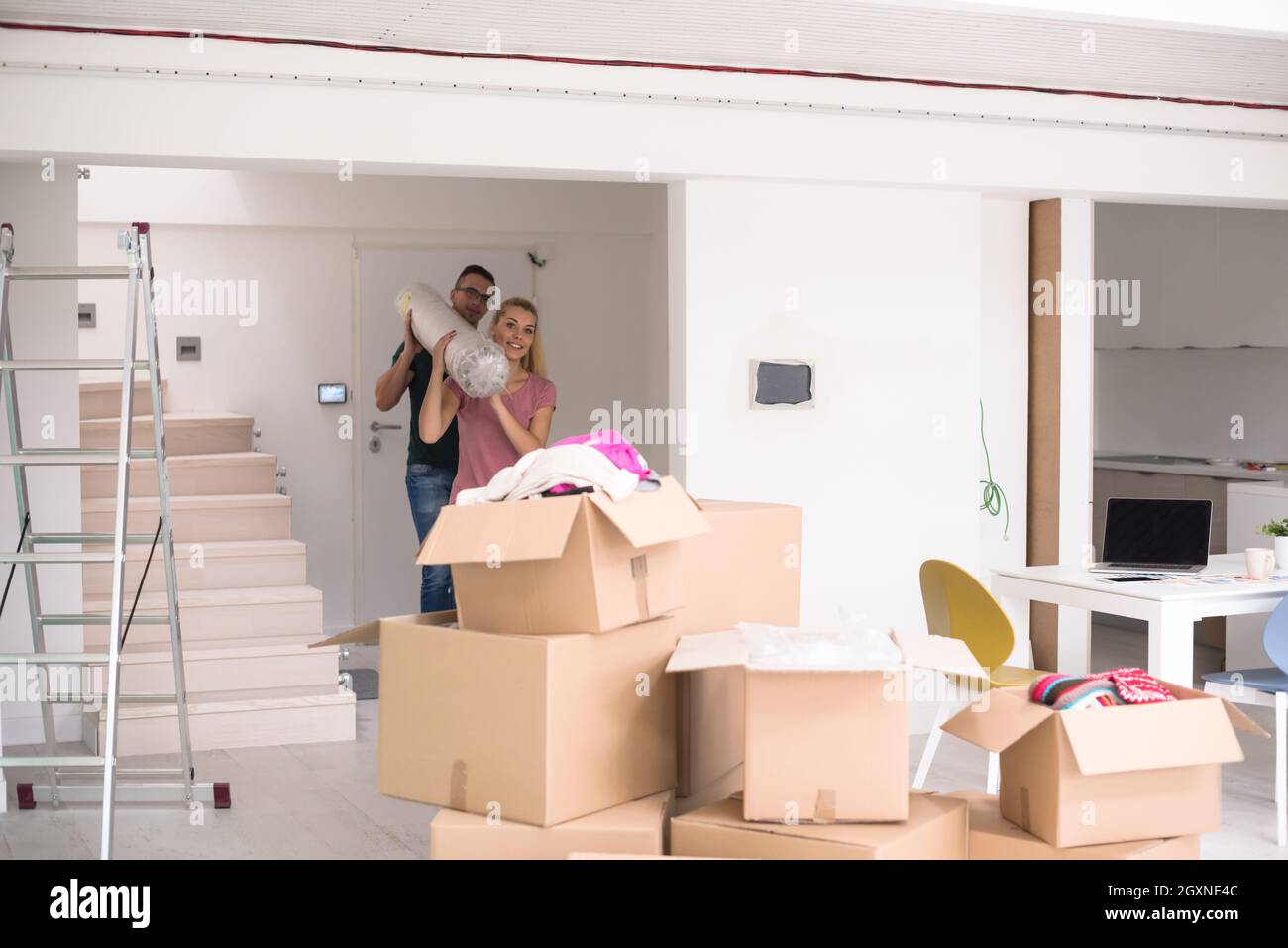 Young couple carrying a carpet moving in to new home together. Home ...