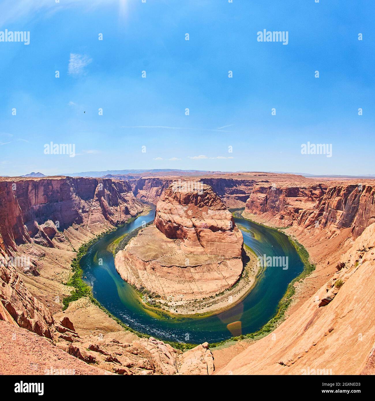 Aerial shot of a canyon surrounding a large river or pond shaped around ...