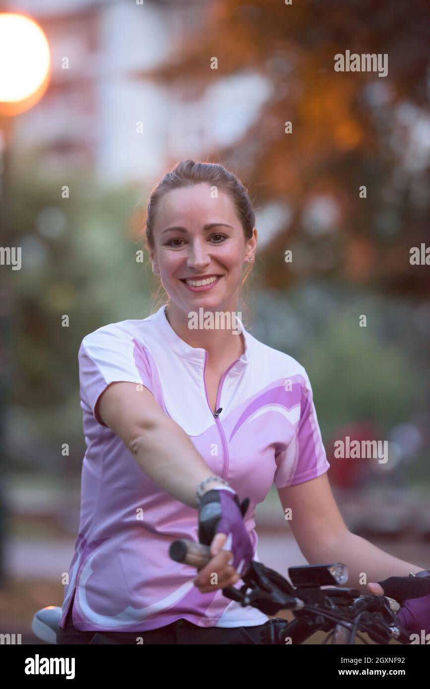 portrait of sporty happy woman with bike in park, taking brake and ...