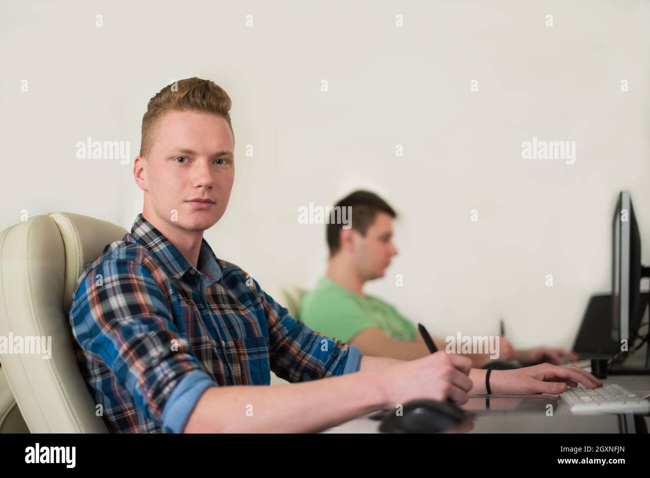 a group of young graphic designers working on a digital tablet and a ...