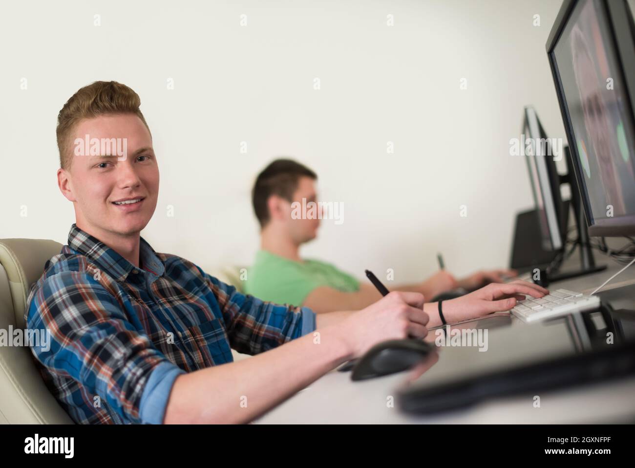 a group of young graphic designers working on a digital tablet and a ...
