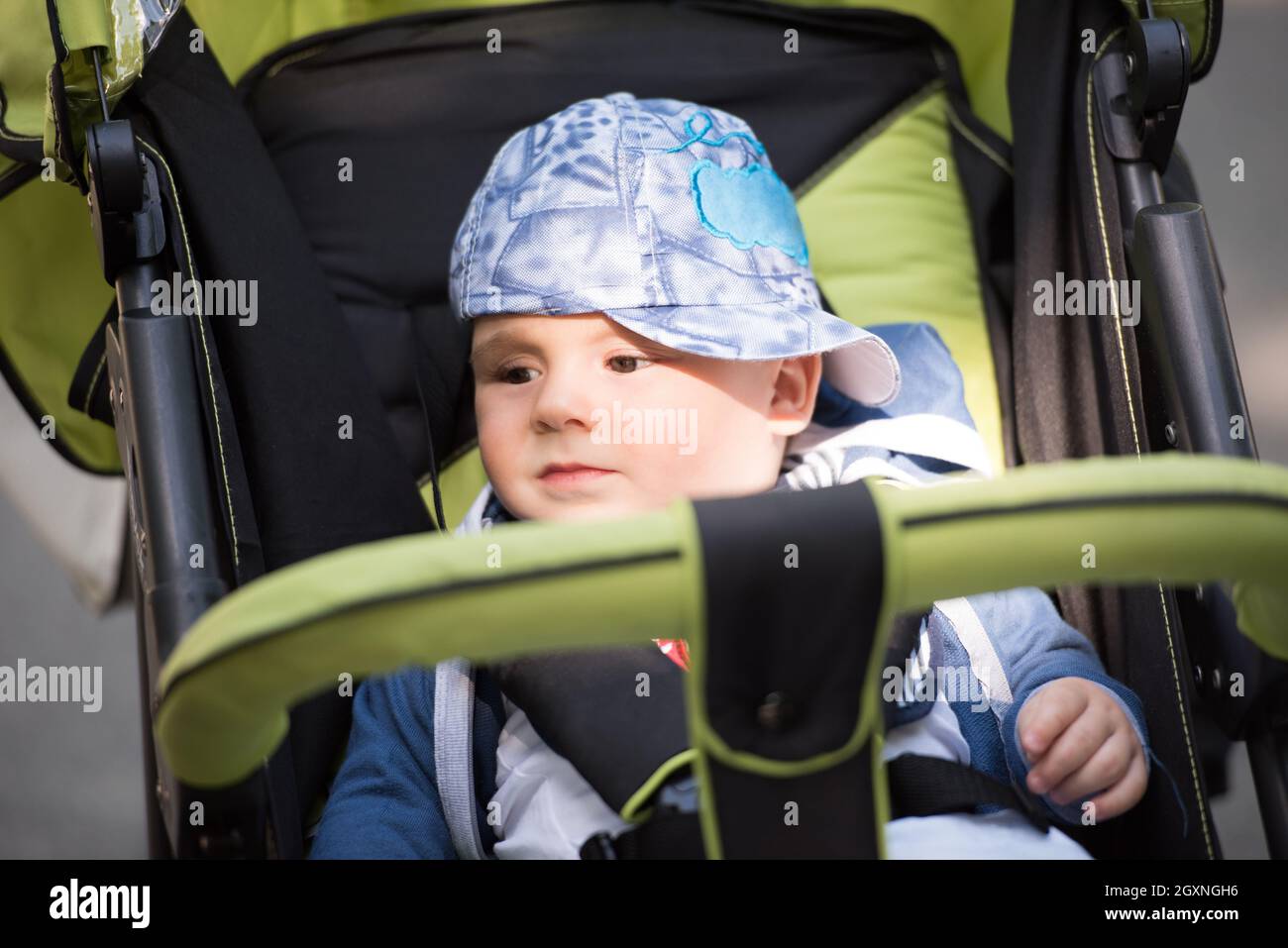 little and very beautiful baby boy sitting in the pram and waiting for ...