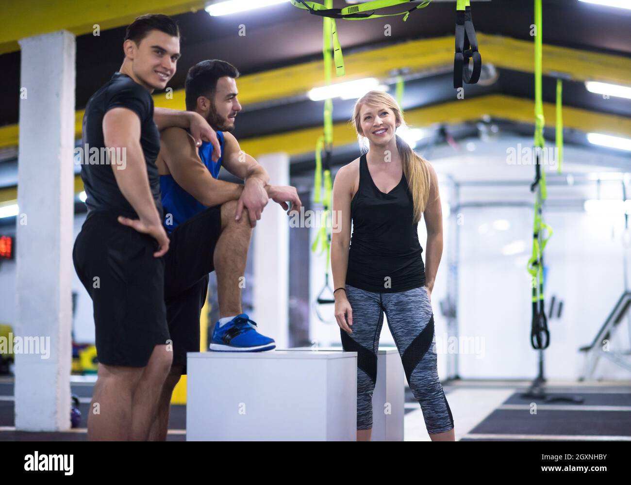 group of young healthy athletic people training jumping on fit box at ...