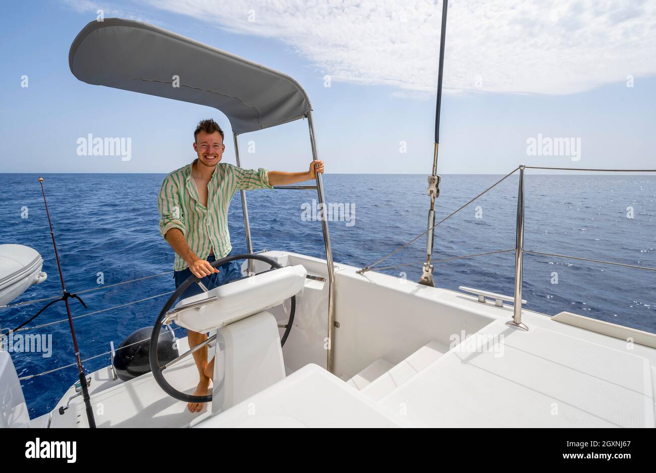 Sailor, Skipper at the helm, Young man sailing on sailing catamaran, Sailing trip, Dodecanese ...
