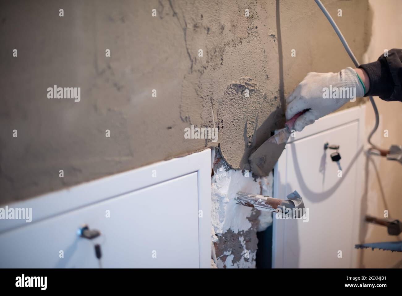 Construction worker plastering interior wall using cement plaster ...