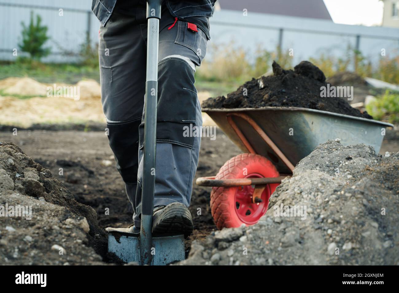 Working with garden tools, shovel and wheelbarrow on the site of a ...
