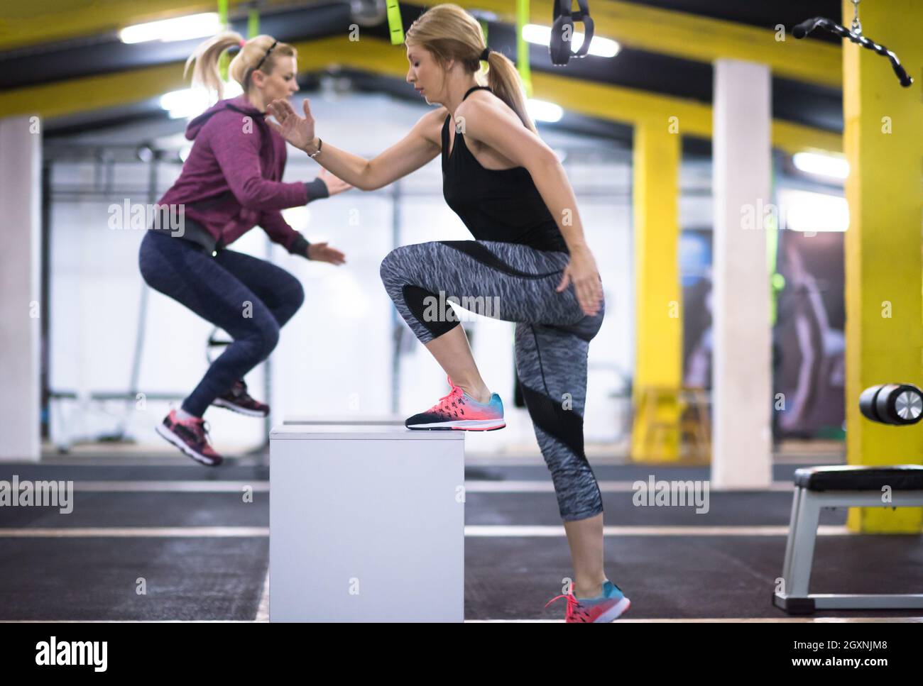 group of young healthy athletic people training jumping on fit box at ...
