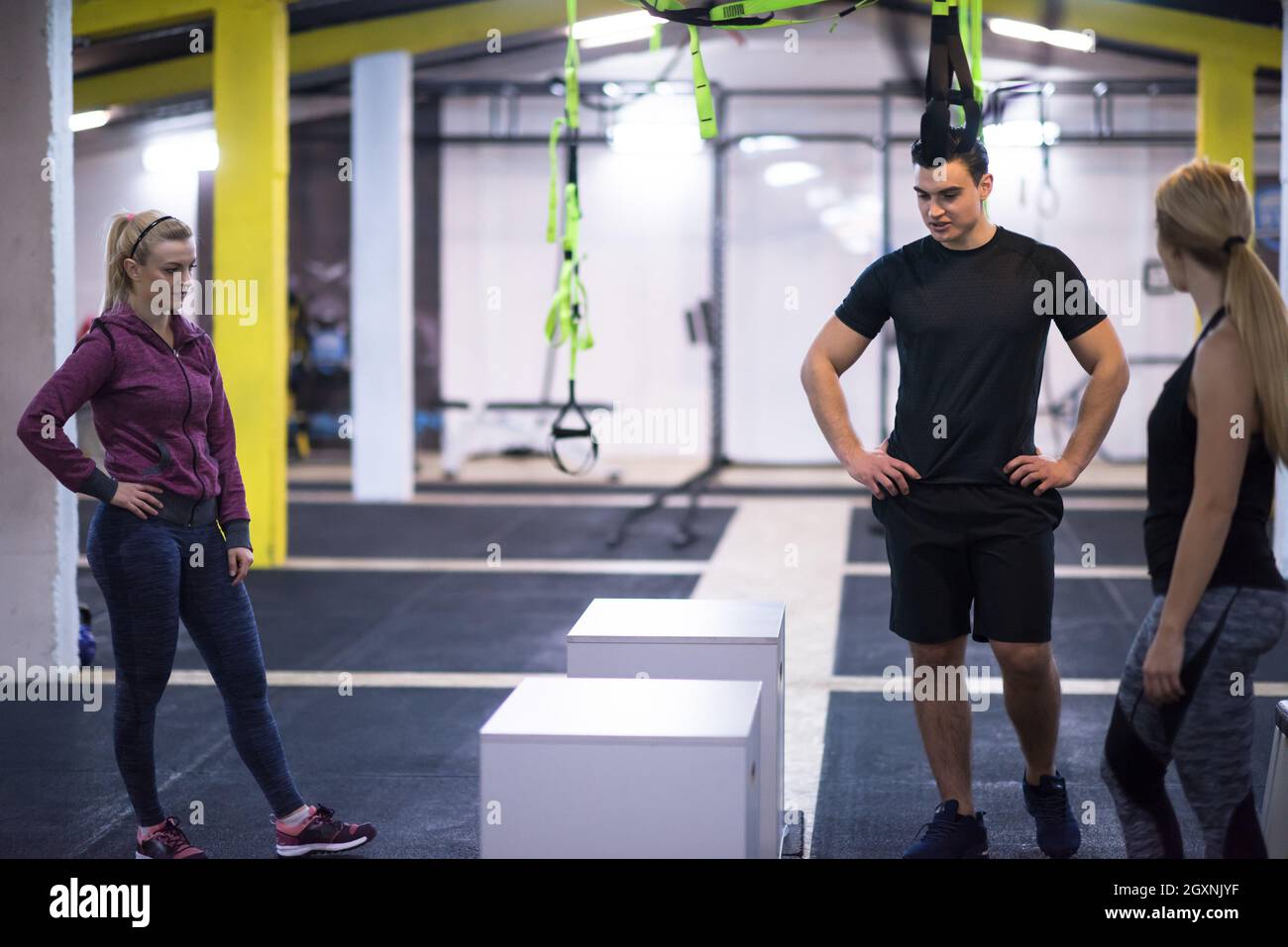 group of young healthy athletic people training jumping on fit box at ...