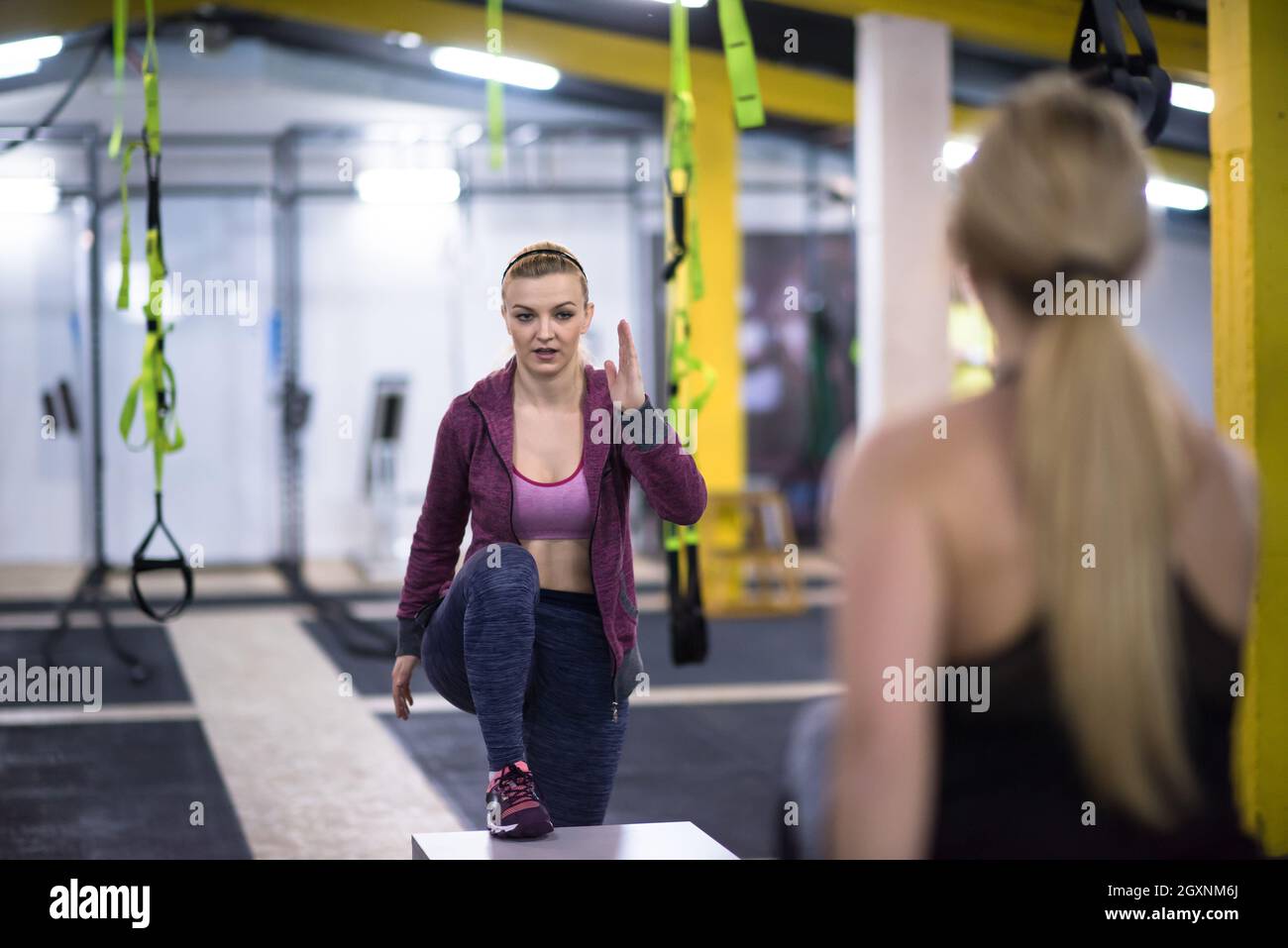 group of young healthy athletic people training jumping on fit box at ...
