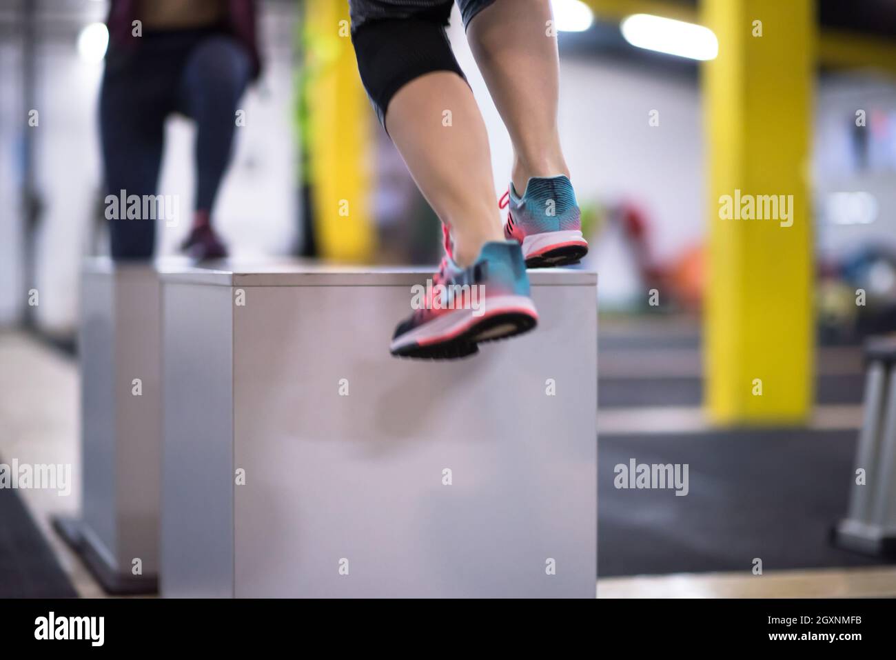 group of young healthy athletic people training jumping on fit box at ...