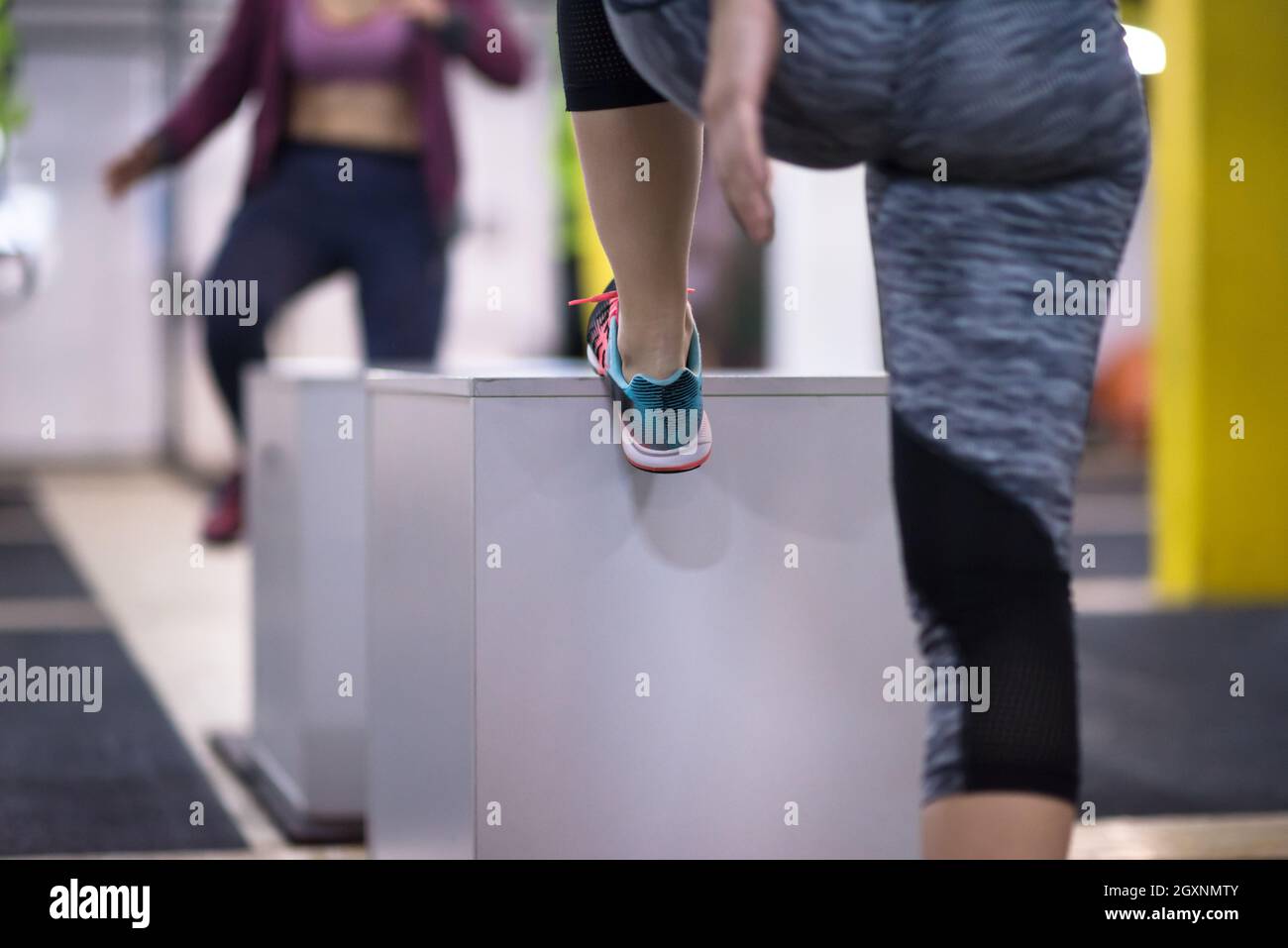 group of young healthy athletic people training jumping on fit box at ...