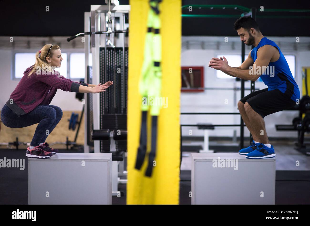 group of young healthy athletic people training jumping on fit box at ...