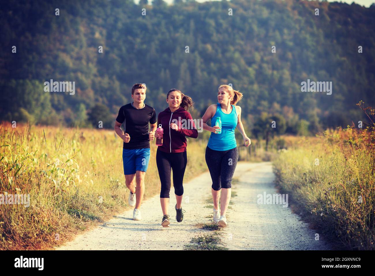 group of young people jogging on country road runners running on open ...