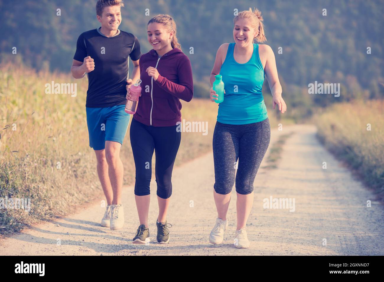 group of young people jogging on country road runners running on open ...