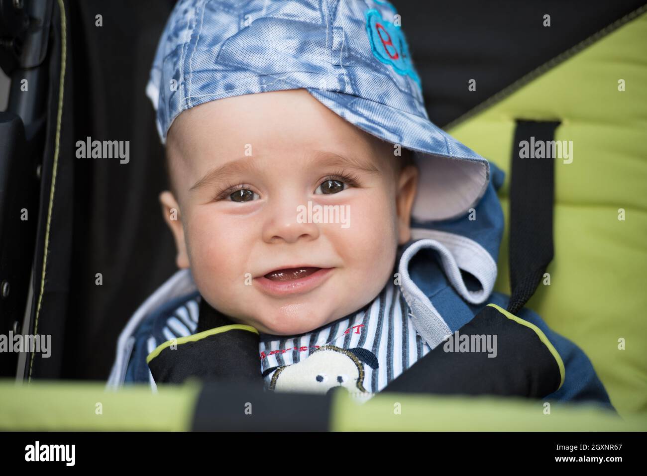 little and very beautiful baby boy sitting in the pram and waiting for ...