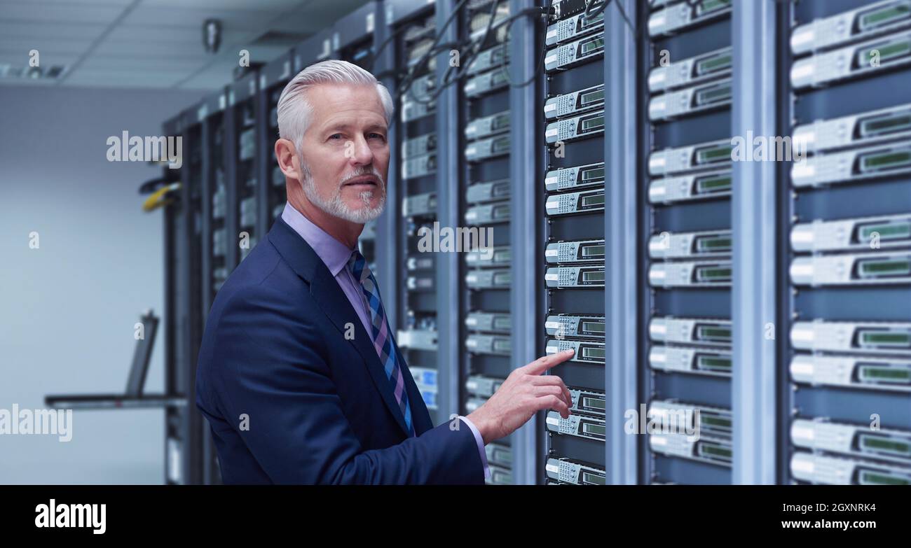 Portrait of senior businessman working in big rack server room Stock ...