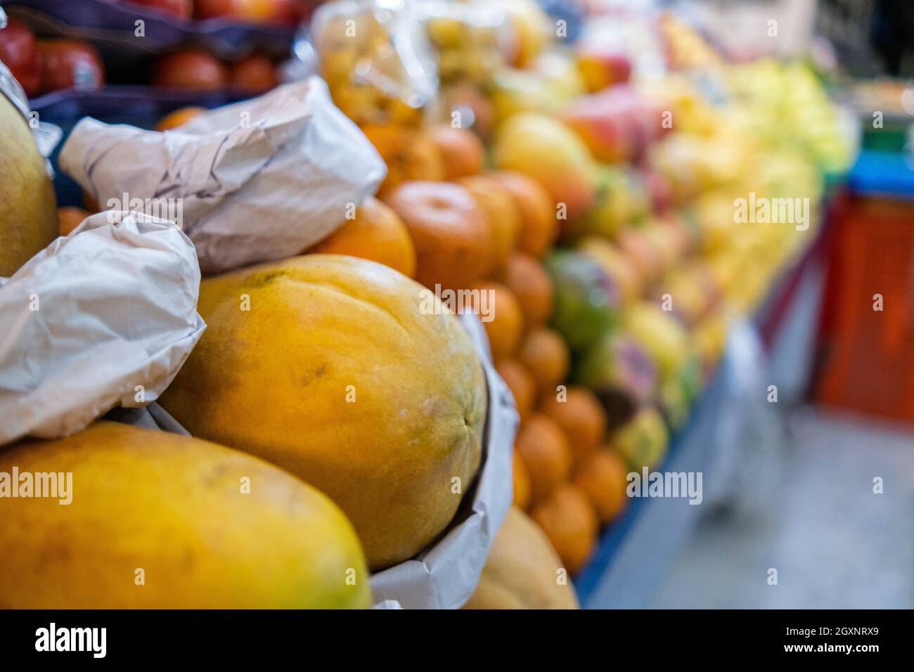 Colorful fruit stand with fresh papayas, tangerines, apples, mangoes ...