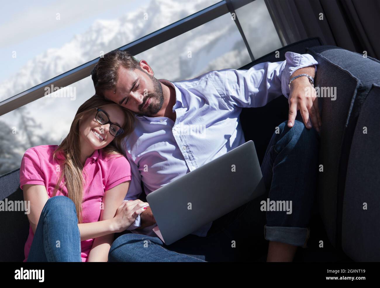 Young couple relaxing at home using laptop computers reading in the ...