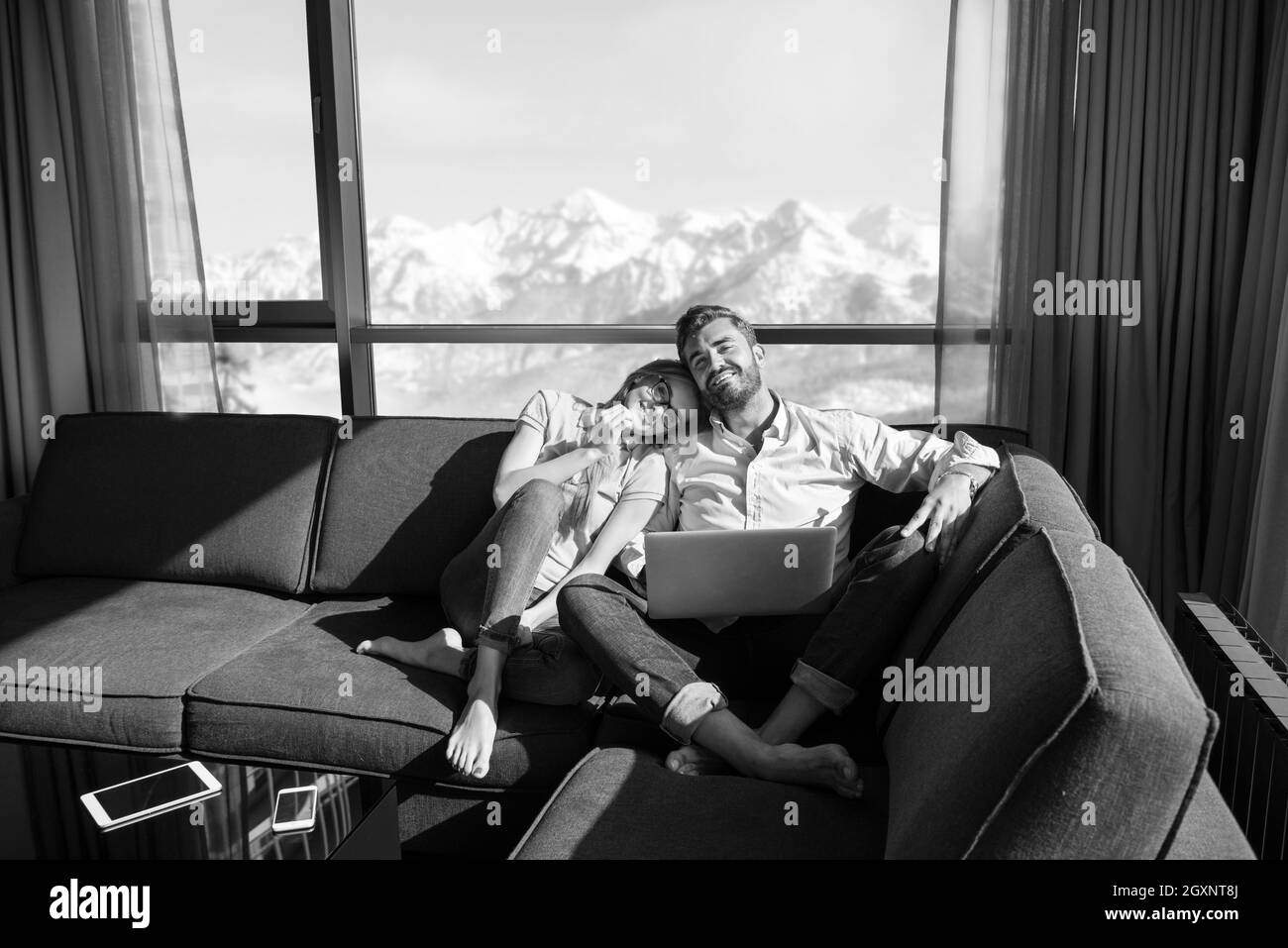 Young couple relaxing at home using laptop computers reading in the ...