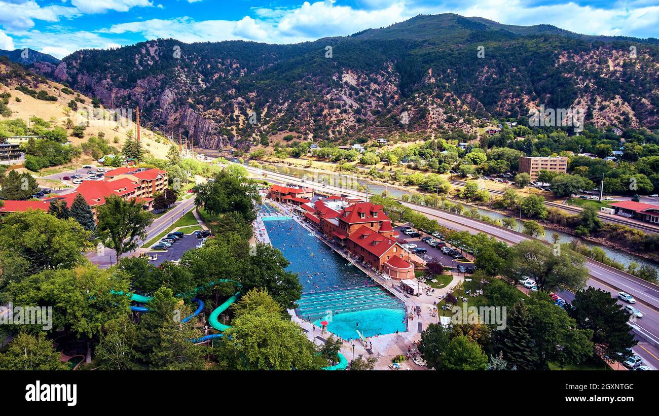 Large hot spring in town next to rocky mountains Stock Photo - Alamy
