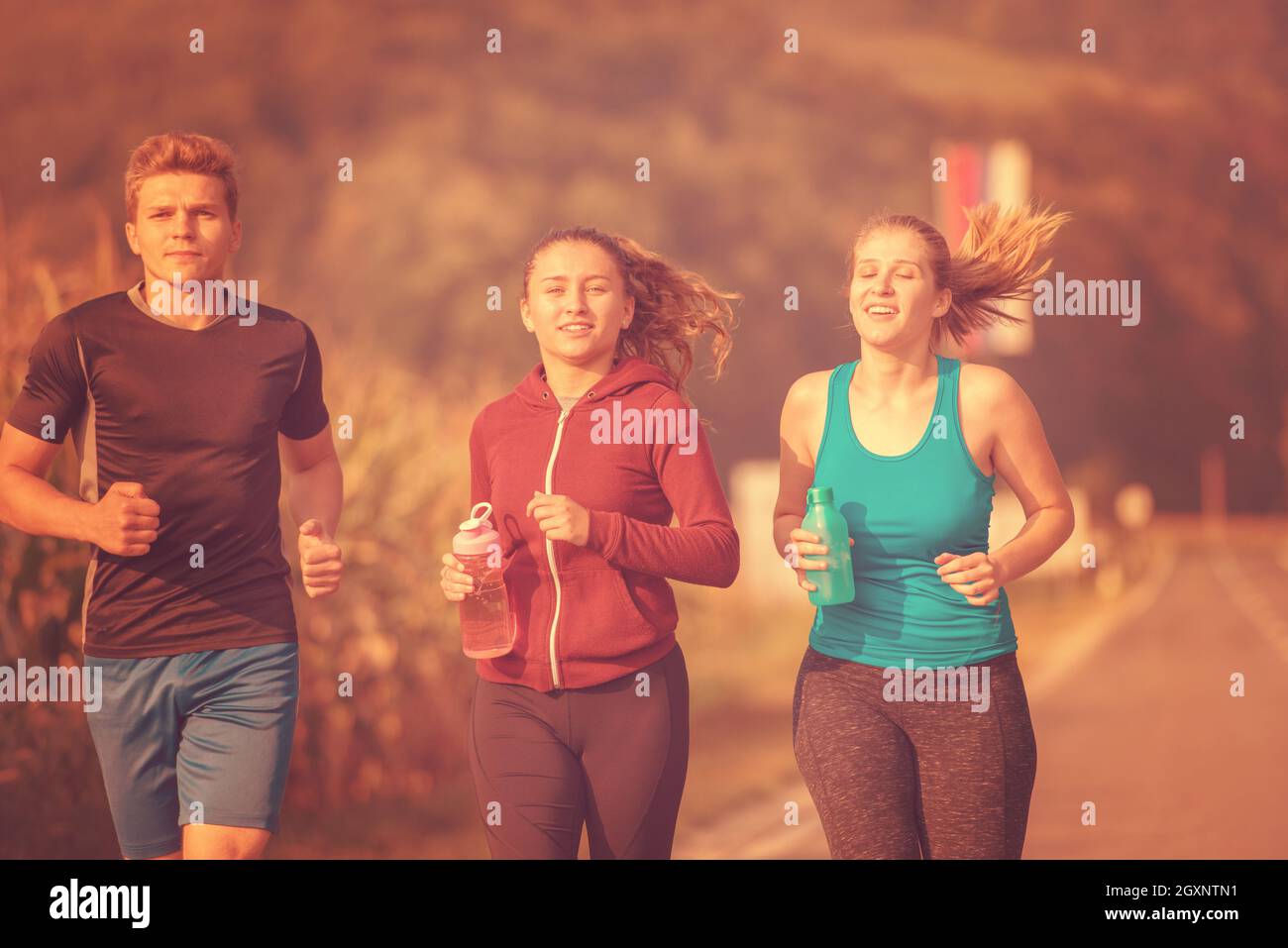 group of young people jogging on country road runners running on open ...