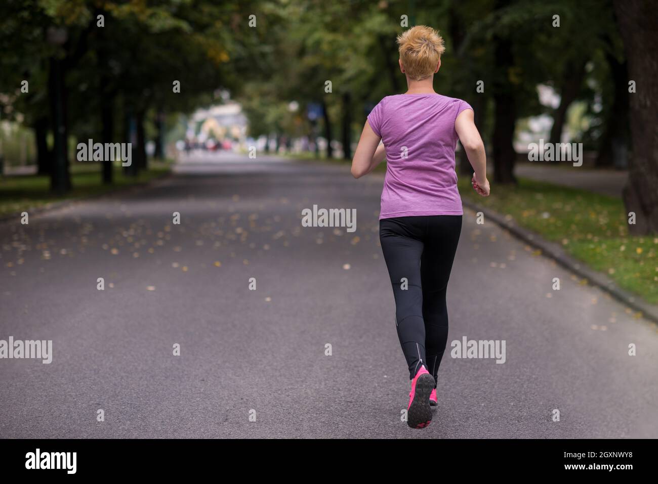 fit muscular female runner training for marathon running at morning on ...