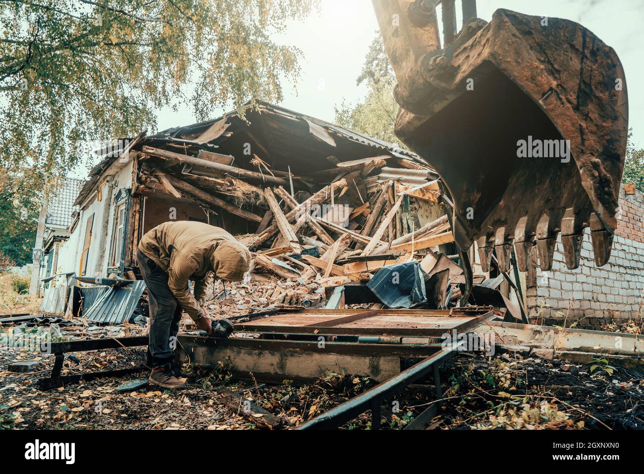 Worker sawing iron at construction site when demolishing house with ...
