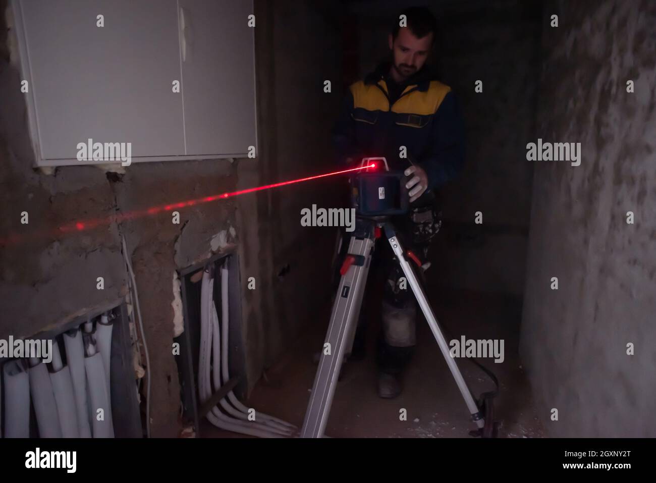professional worker using laser level in a building under construction ...
