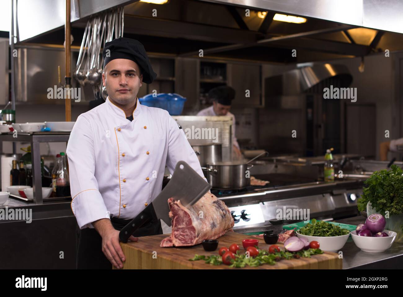 chef using ax while cutting big piece of beef on wooden board in ...