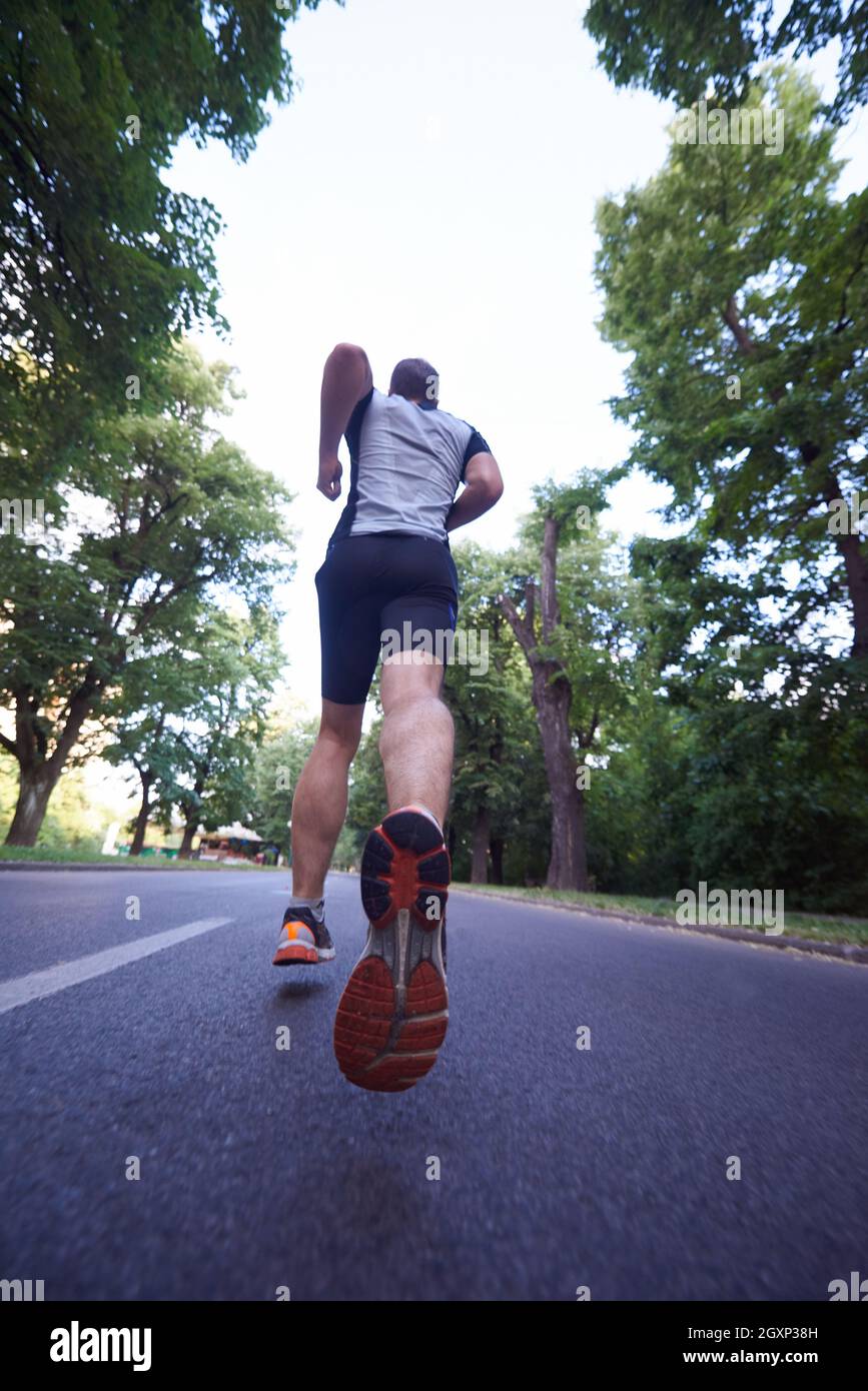 healthy athlete man jogging at morning on empty roat in the city Stock ...