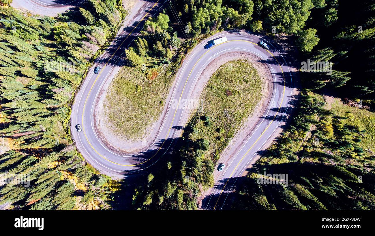 Road curving heavily down mountain with pine trees Stock Photo - Alamy