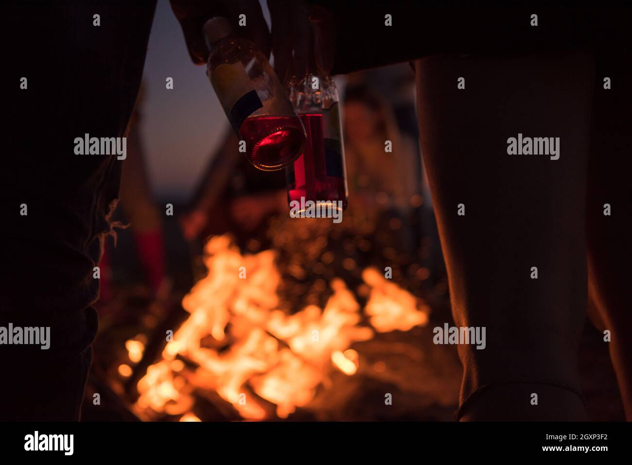 Happy Carefree Young Friends Having Fun And Drinking Beer By Bonefire ...