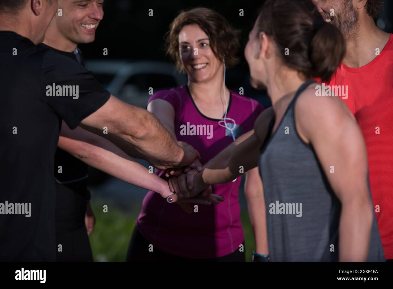 Group of healthy runners giving high five to each other while ...