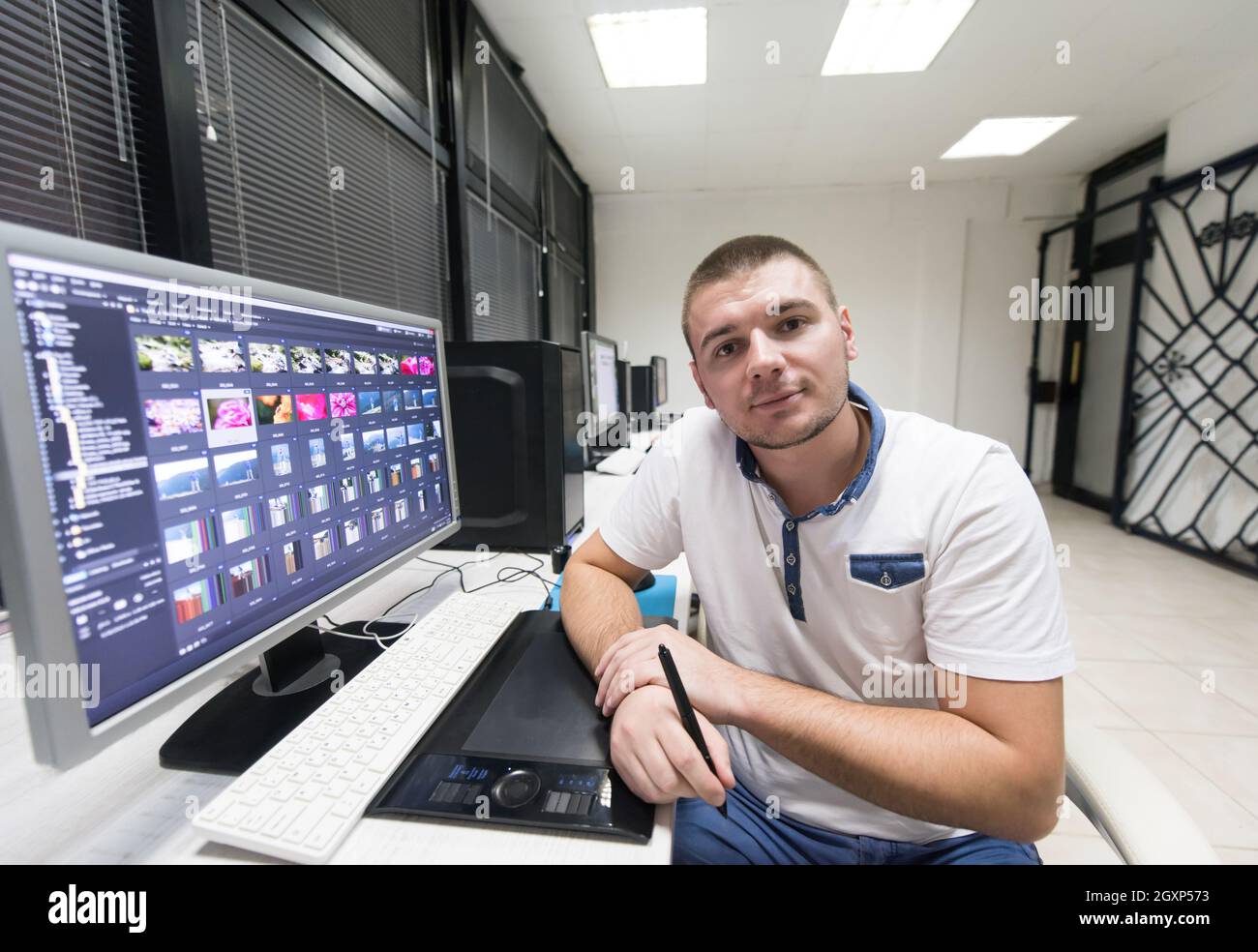 creative worker, photo editor working on graphic tablet at his desktop ...