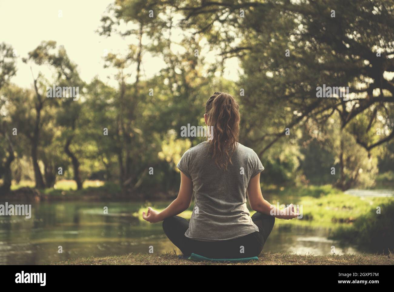 healthy woman relaxing while meditating and doing yoga exercise in the ...