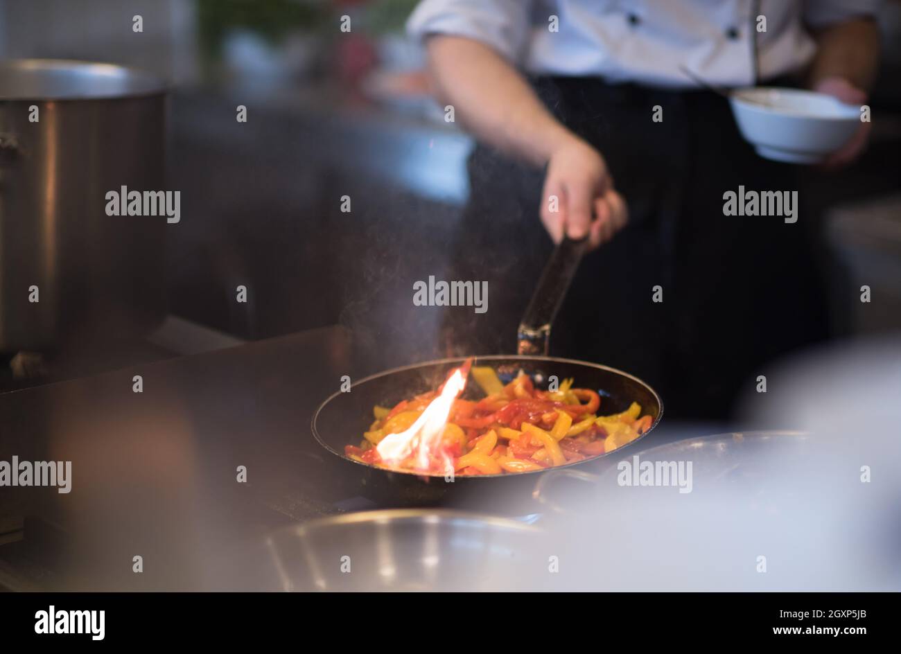 Chef cooking and doing flambe on food in restaurant kitchen Stock Photo ...