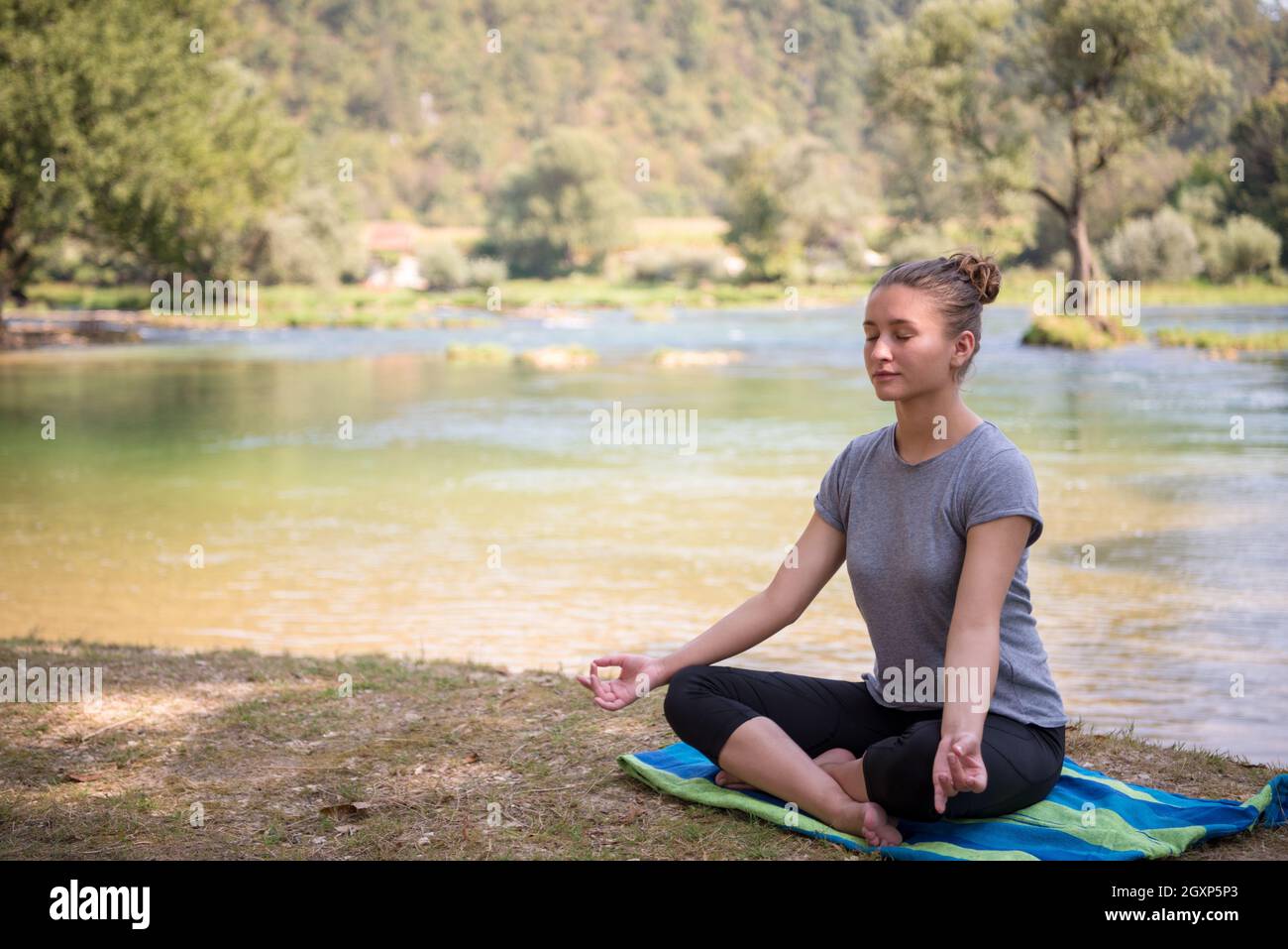 healthy woman relaxing while meditating and doing yoga exercise in the ...