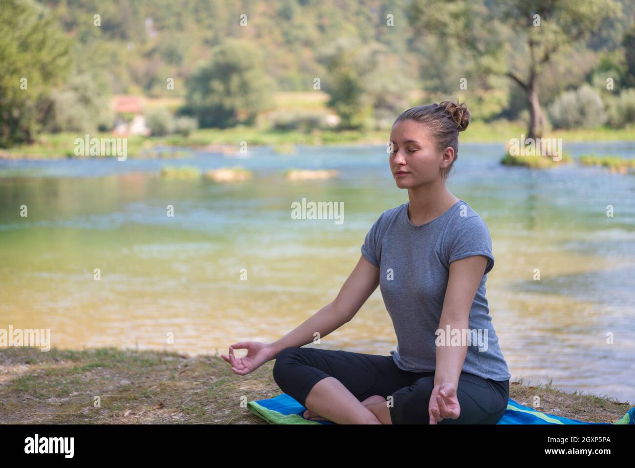 healthy woman relaxing while meditating and doing yoga exercise in the ...