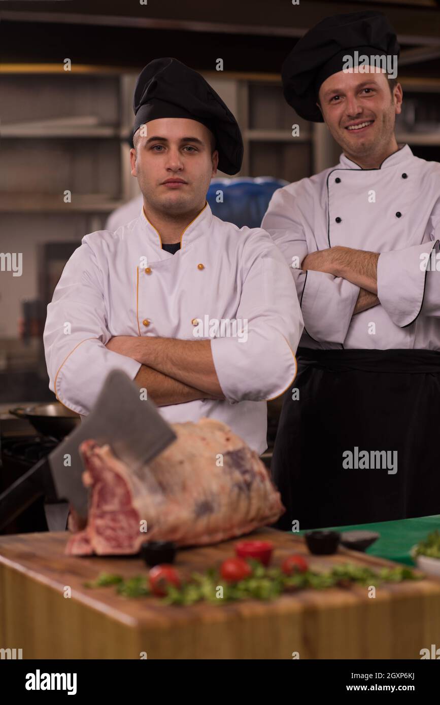 Portrait of two chefs standing together in commercial kitchen at ...